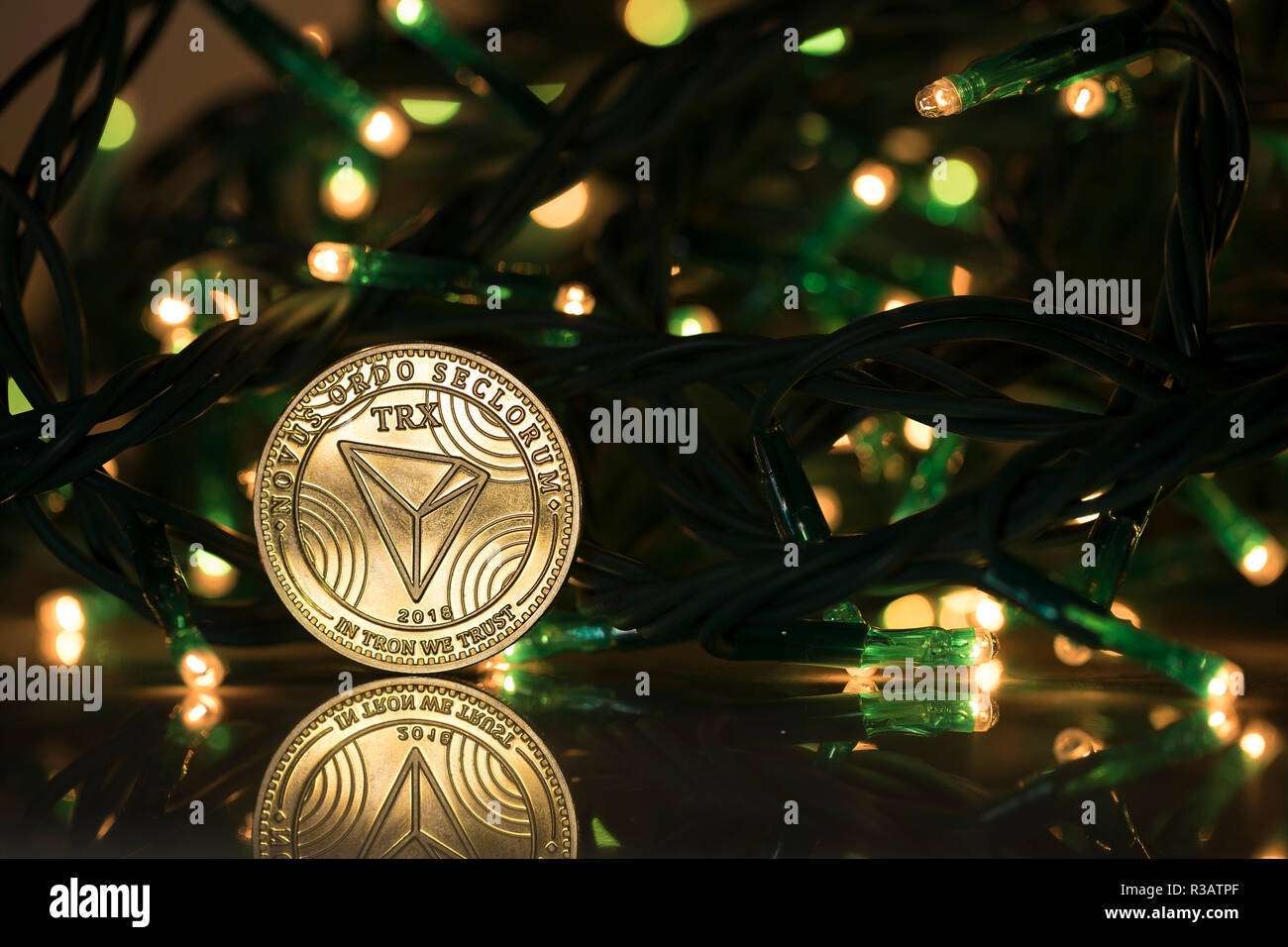 Tron cryptocurrency physical coin surrounded with Christmas tree lights ...
