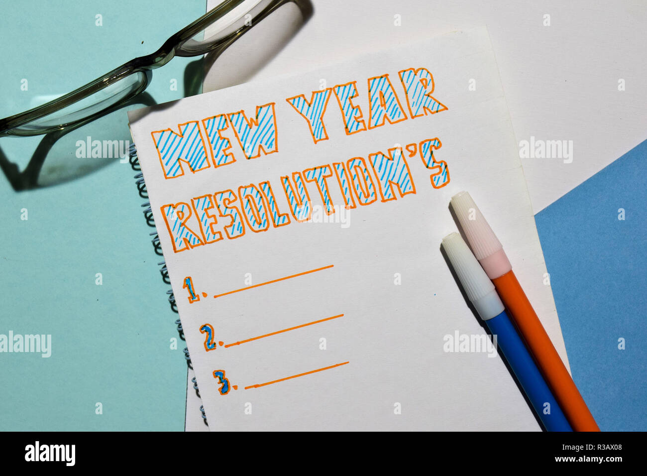 Top view New Year Resolutions text list with marker and eyeglasses for ...