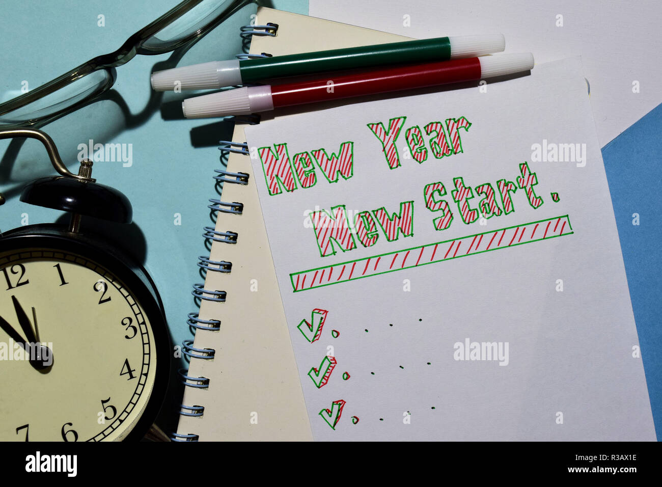 Top view NEW YEAR NEW START text list with alarm clock, marker and ...
