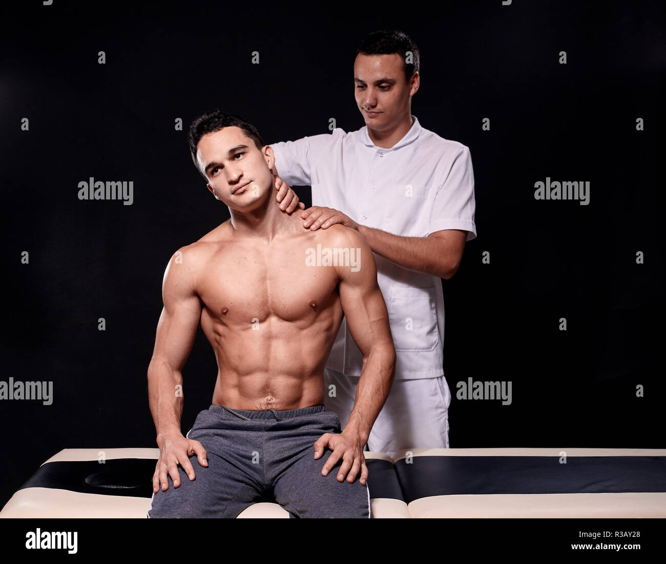 two young man, 20-29 years old, sports physiotherapy indoors in studio ...