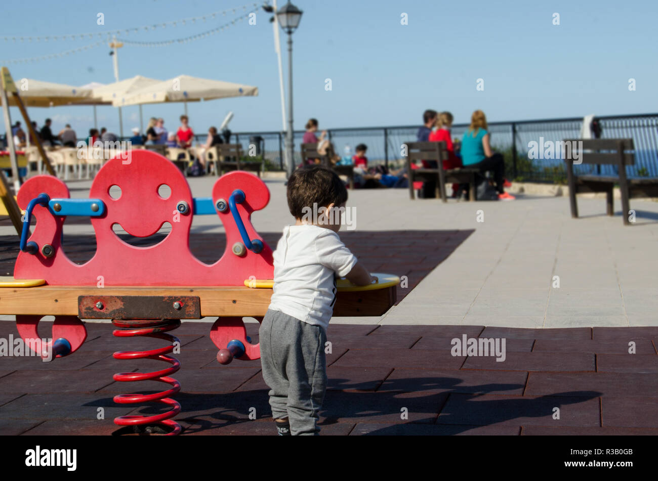 toddler playing alone in the park - lonely child concept Stock Photo ...