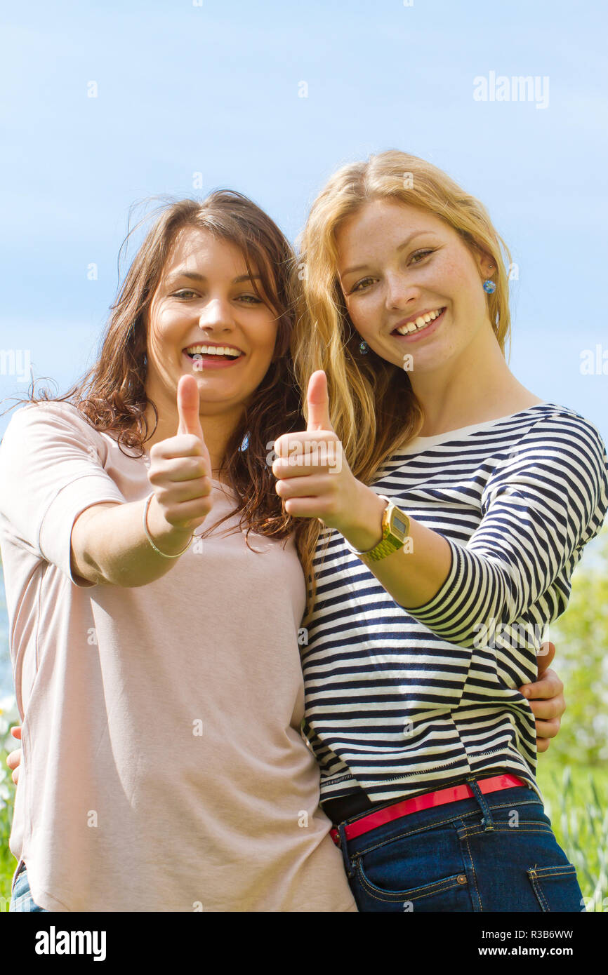 two young women in the spring with thumbs up Stock Photo - Alamy