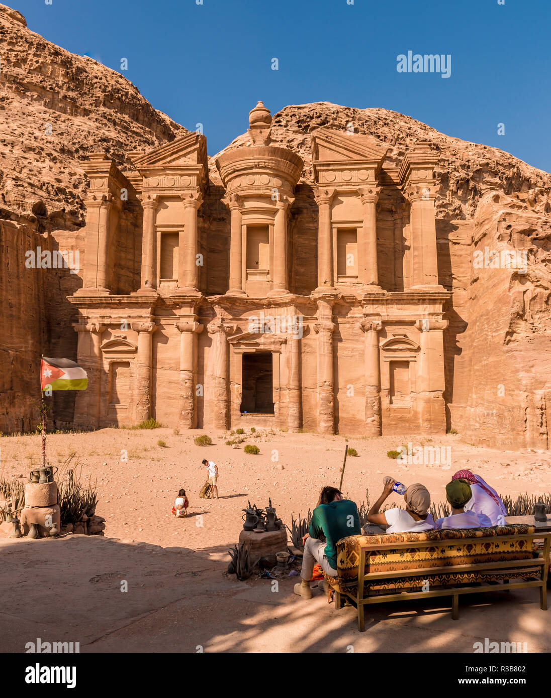 Tourists sitting on a bench, monastery, rock temple Ad Deir, rock tomb ...