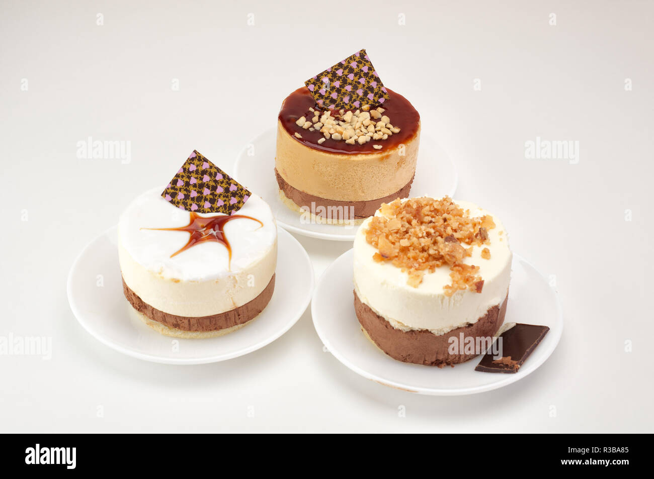 Three delicious cakes on plates, isolated on white background Stock ...