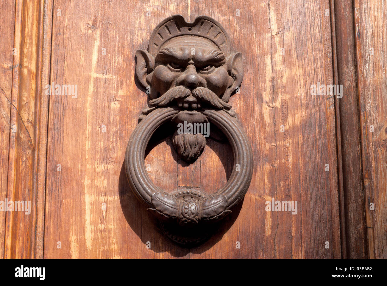 Old rusty door knocker with a human face Stock Photo - Alamy