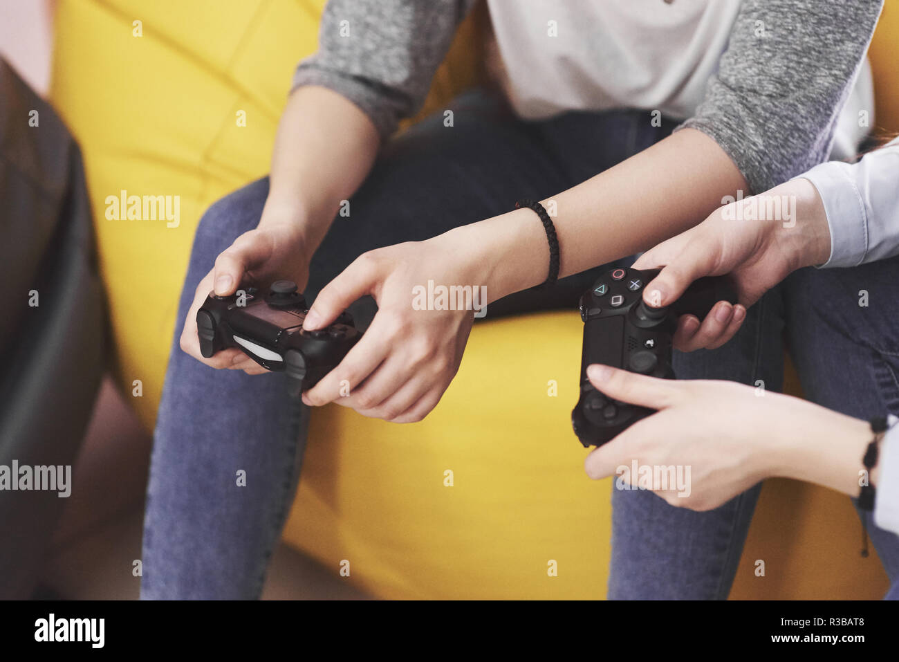 Twin sister sisters play on the console. Girls hold joysticks in their ...
