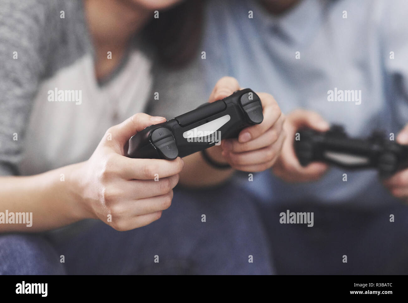 Twin sister sisters play on the console. Girls hold joysticks in their ...