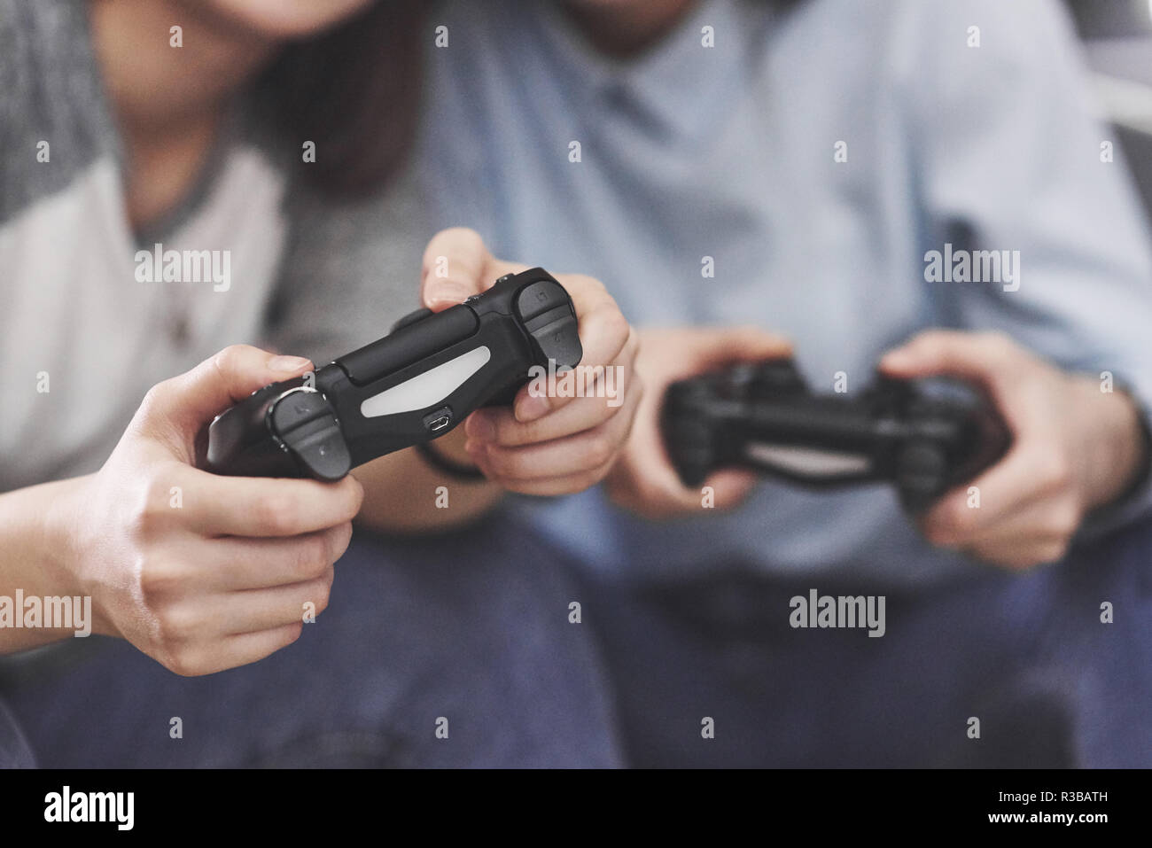 Twin sister sisters play on the console. Girls hold joysticks in their ...