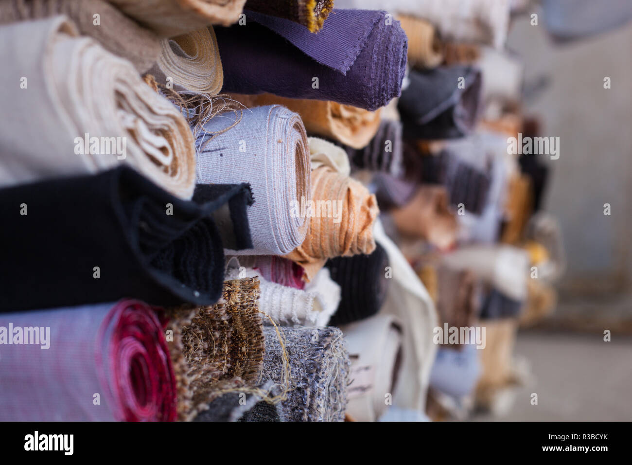 Fabric folded with rolls of different colors folded on top of each ...