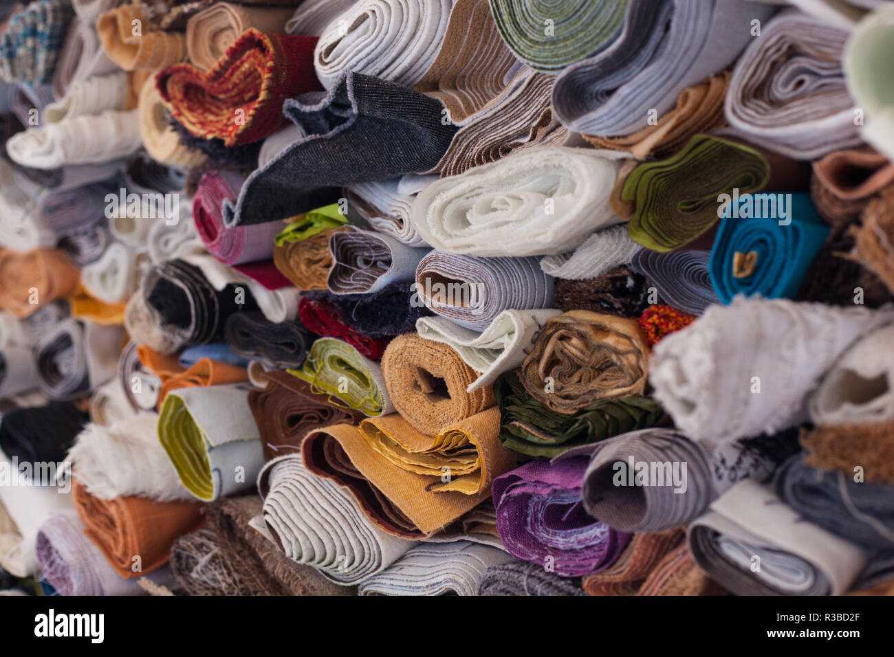 Fabric folded with rolls of different colors folded on top of each ...