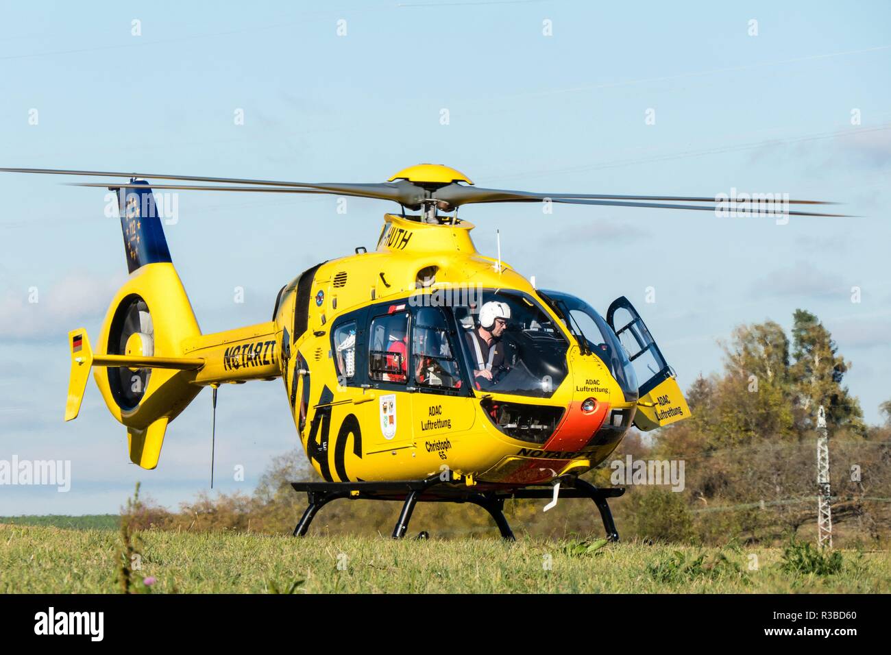 Yellow ADAC medivac helicopter ( Airbus Helicopters EC 135 ) on grass ...