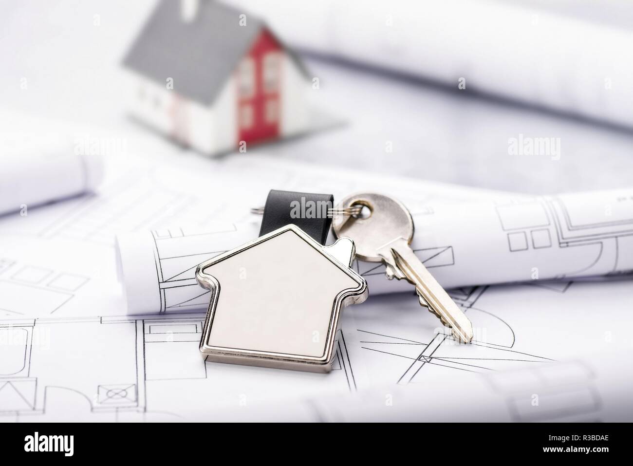 Blueprints and house as a key ring with architectural model in the ...