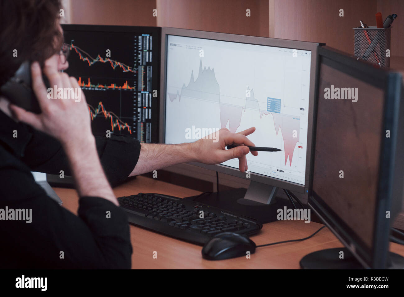 Over the shoulder view of and stock broker trading online while ...