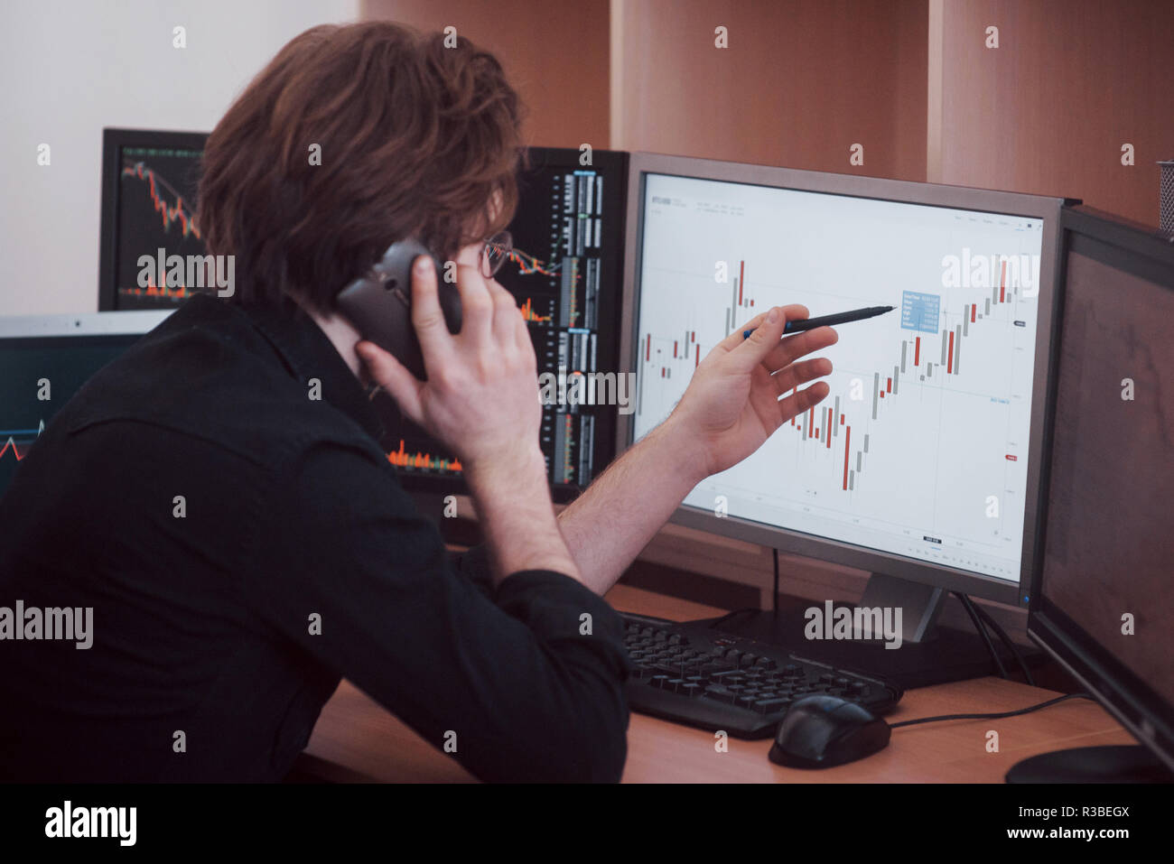 Over the shoulder view of and stock broker trading online while ...