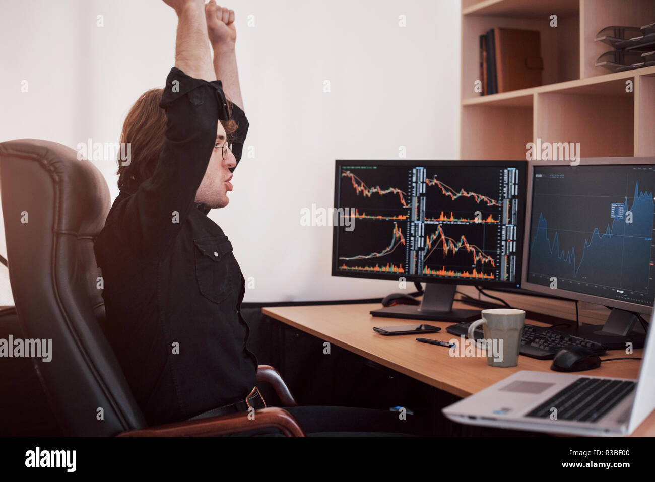 Young stock trader broker stretching hands at workplace, he first ...