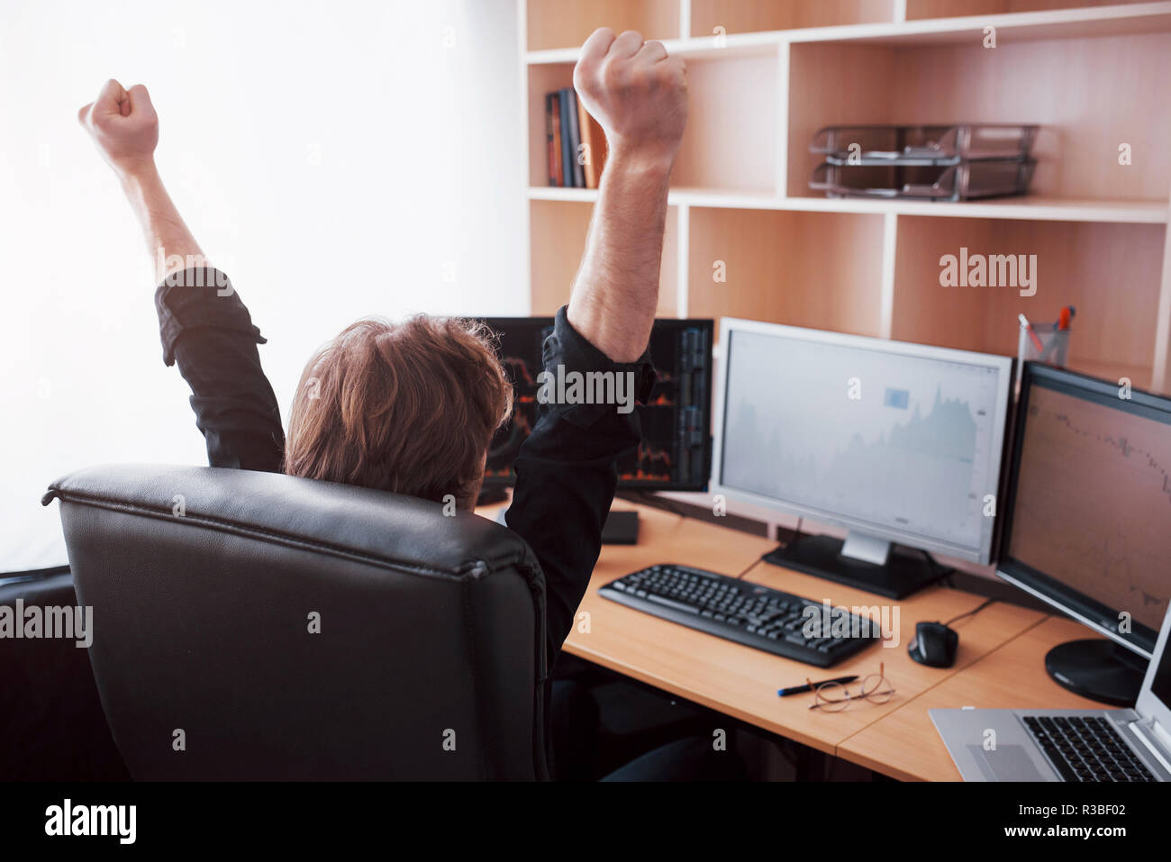 Young stock trader broker stretching hands at workplace, he first ...