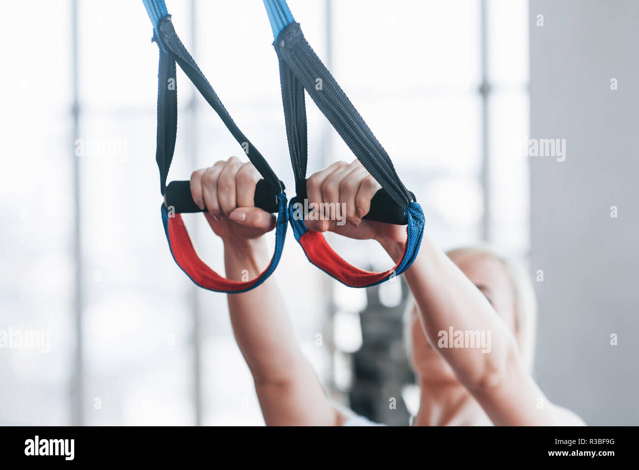 Women doing push ups training arms with trx fitness straps in the gym ...