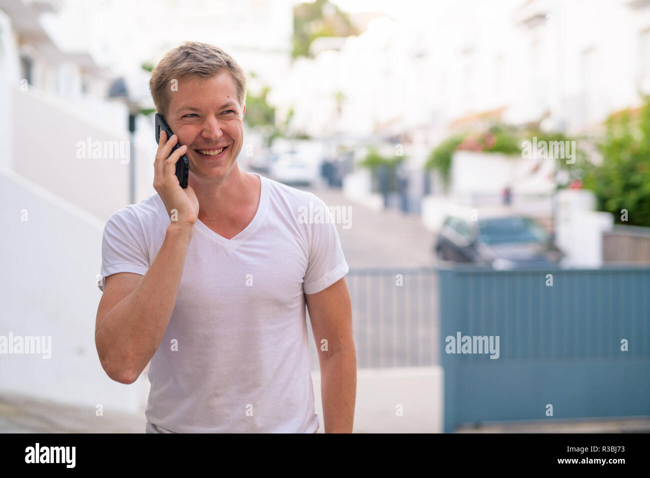 Young Happy Man Thinking While Talking On The Phone Outdoors Stock ...