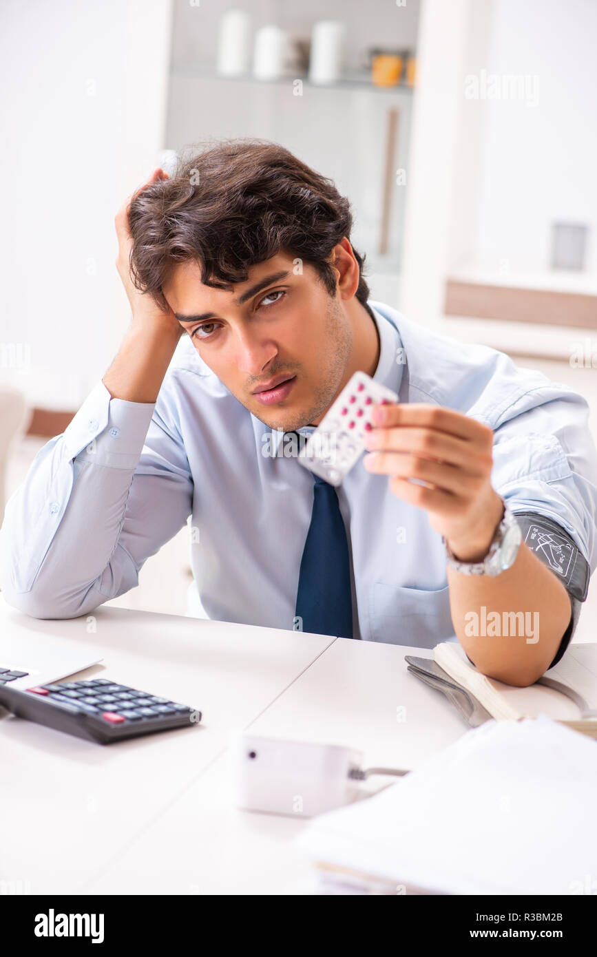 Man under stress measuring his blood pressure Stock Photo - Alamy