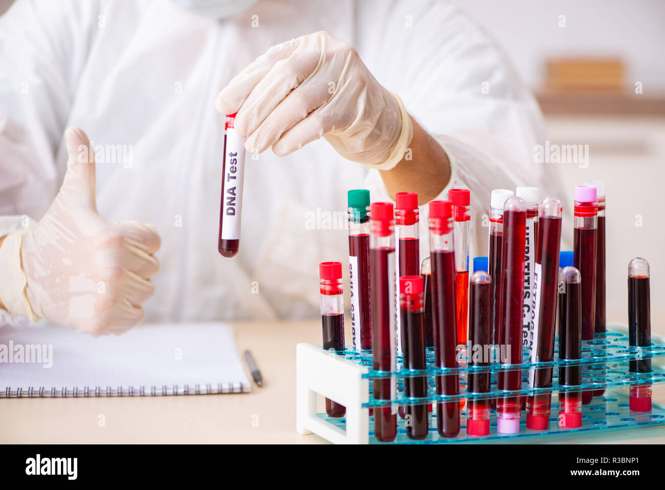 Young handsome lab assistant testing blood samples in hospital Stock ...