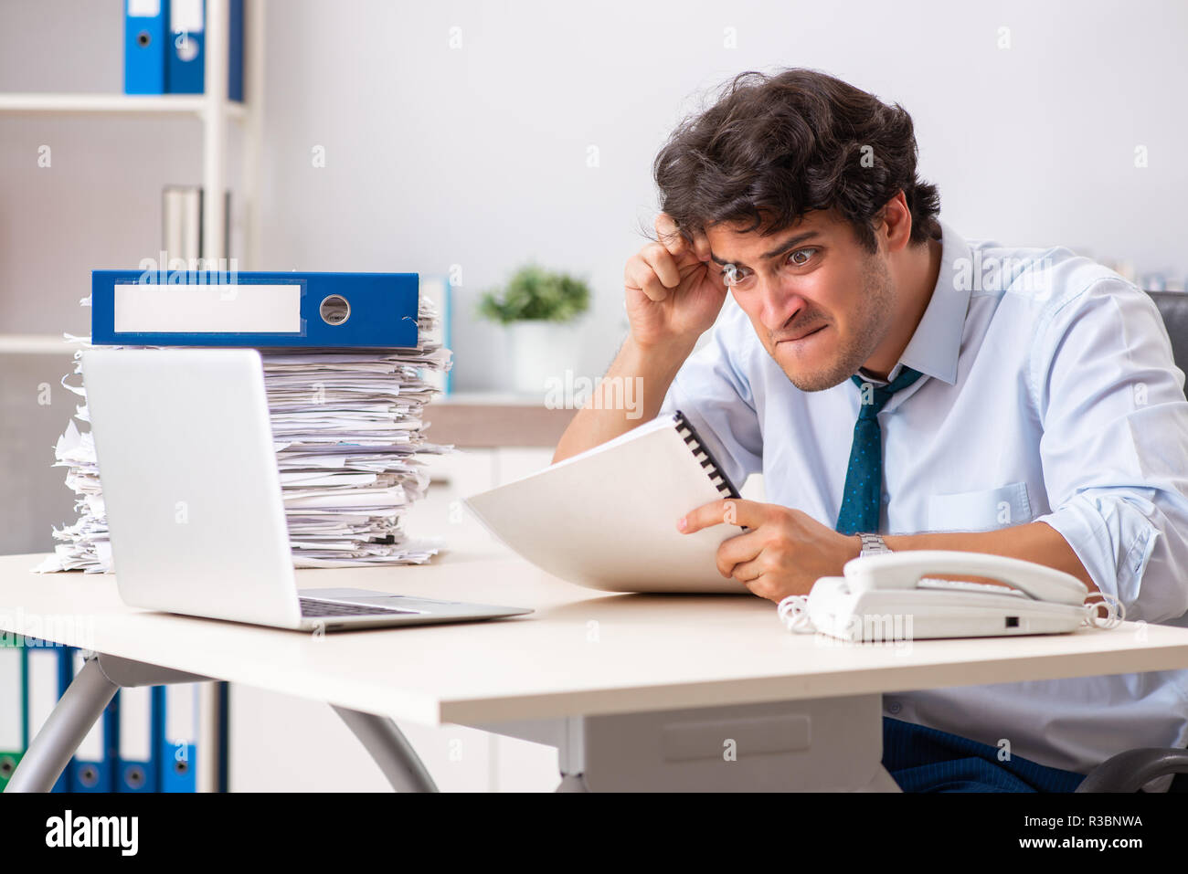 Overloaded busy employee with too much work and paperwork Stock Photo ...