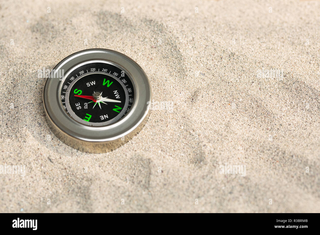 Compass on beige sea sand. Retro navigator when traveling. Background ...
