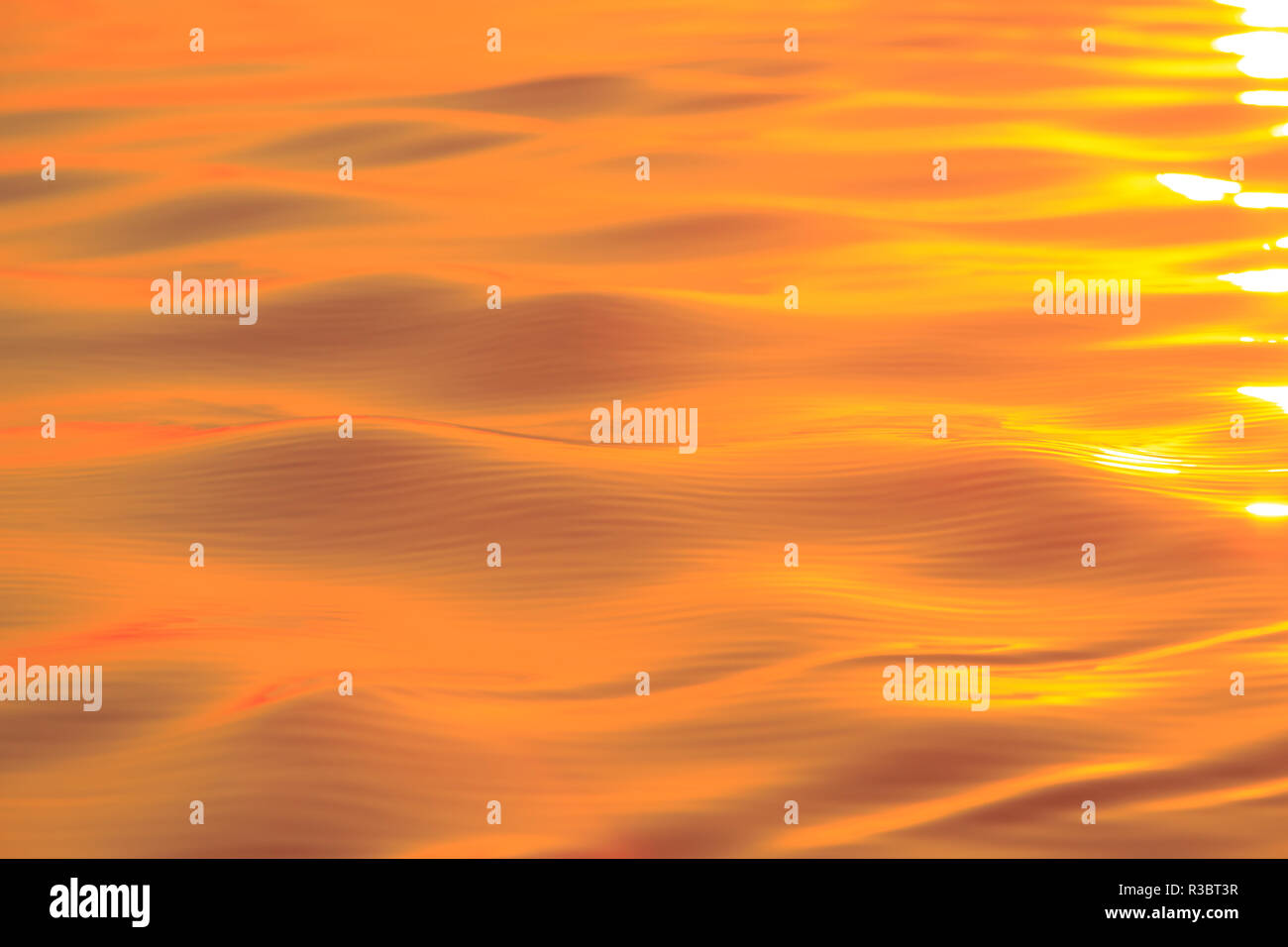 Sunset colors and patterns on small waves in water Stock Photo - Alamy