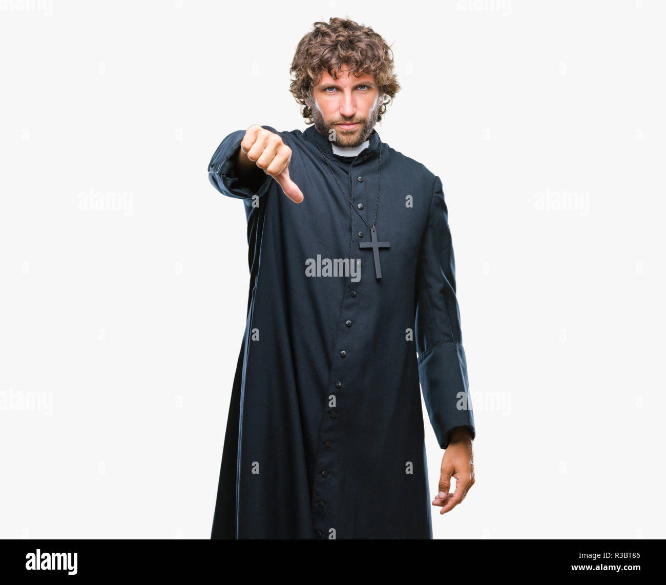 Handsome hispanic catholic priest man over isolated background looking ...