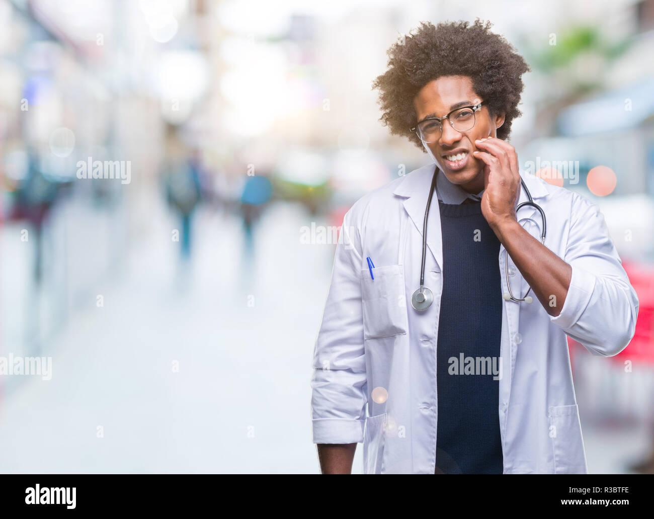 Afro american doctor man over isolated background touching mouth with ...