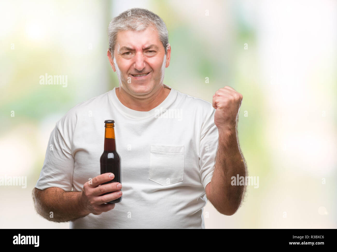 Handsome senior man drinking beer bottle over isolated background ...