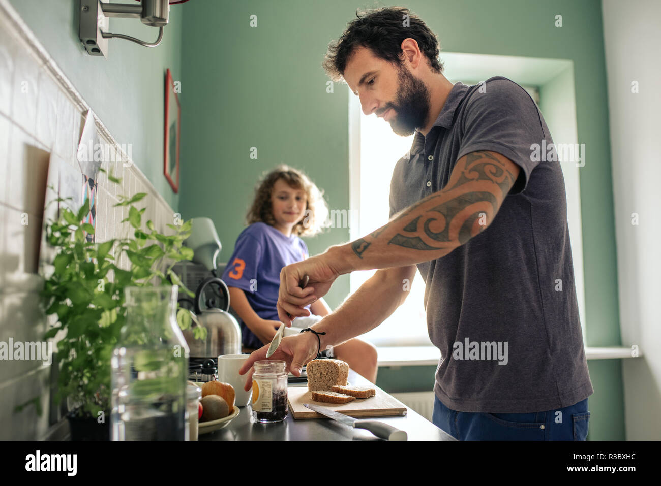 Young boy watching his father make sandwiches in their kitchen Stock ...