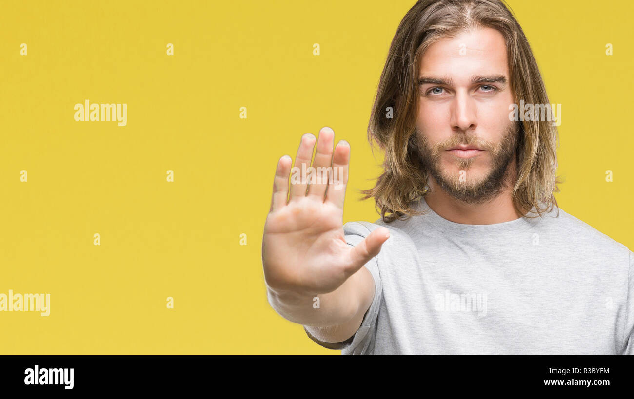 Young handsome man with long hair over isolated background doing stop ...