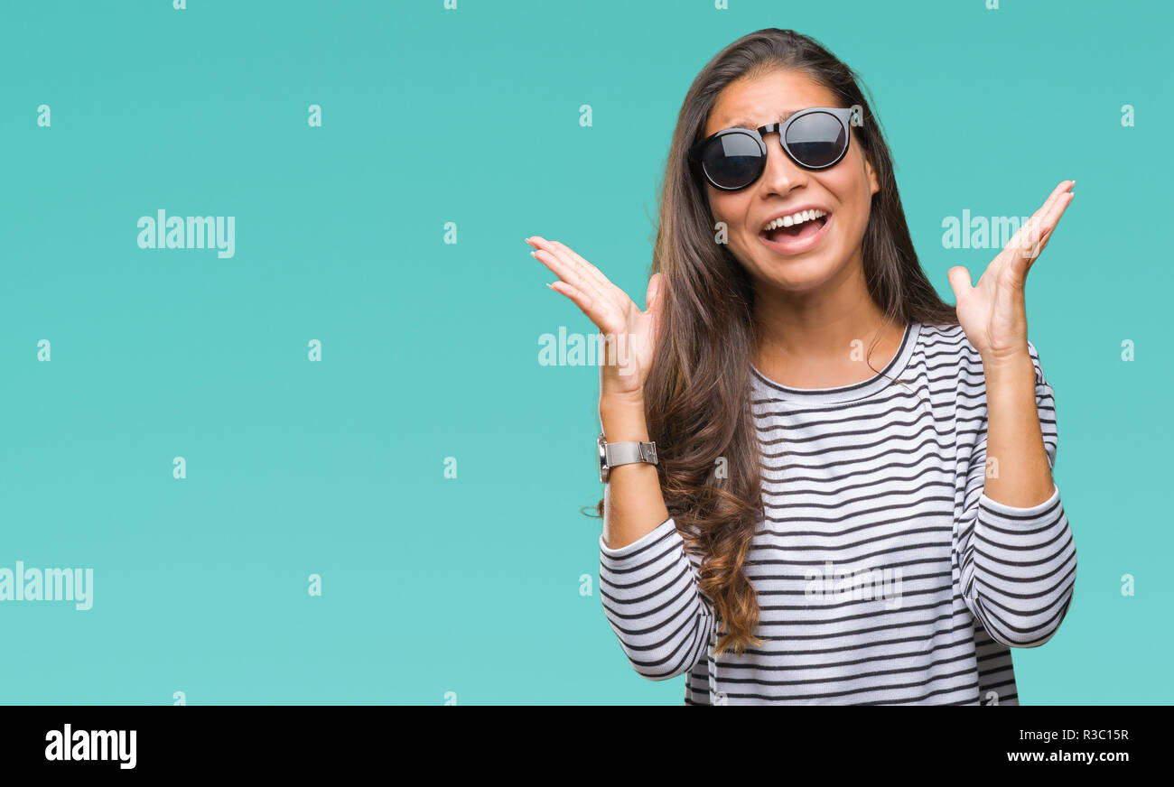Young beautiful arab woman wearing sunglasses over isolated background ...