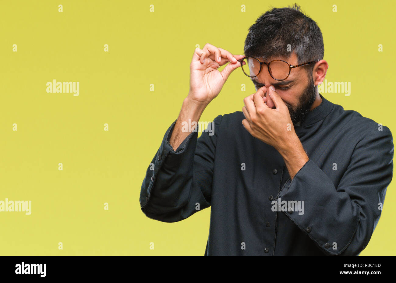 Adult hispanic catholic priest man over isolated background tired ...
