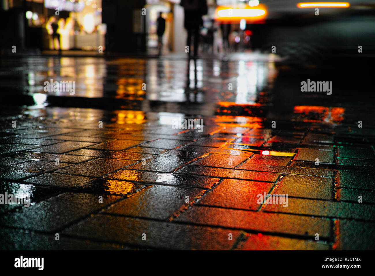 Orange tones reflected on the road at a busy crossing Stock Photo - Alamy