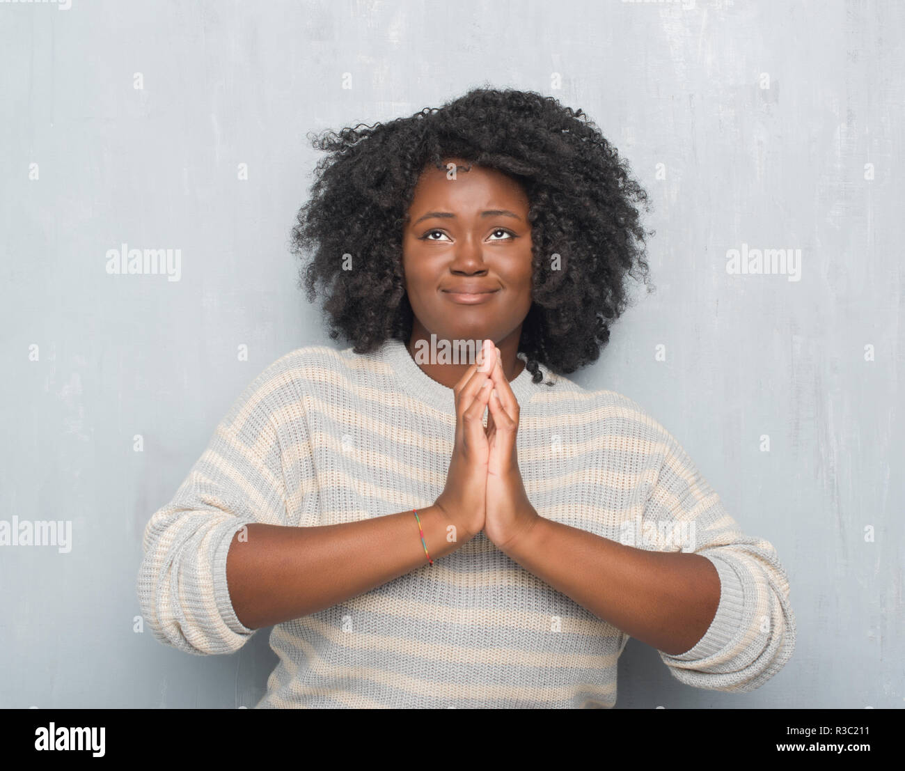 Young african american plus size woman over grey grunge wall wearing a ...