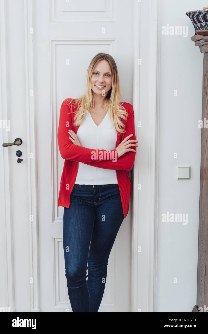 Portrait Of Young Cheerful Woman Wearing Red Sweater Standing By White