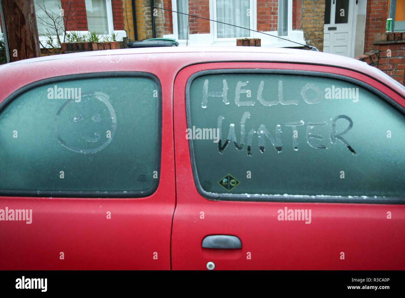 Hello Winter and a smiley face, is seen on a car windscreen covered in ...