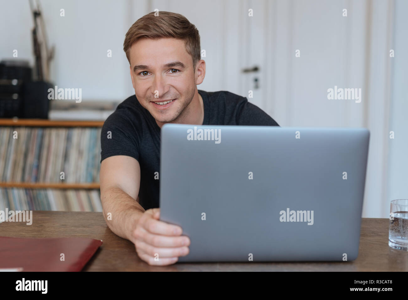 A man seated at a table with a laptop hi-res stock photography and ...