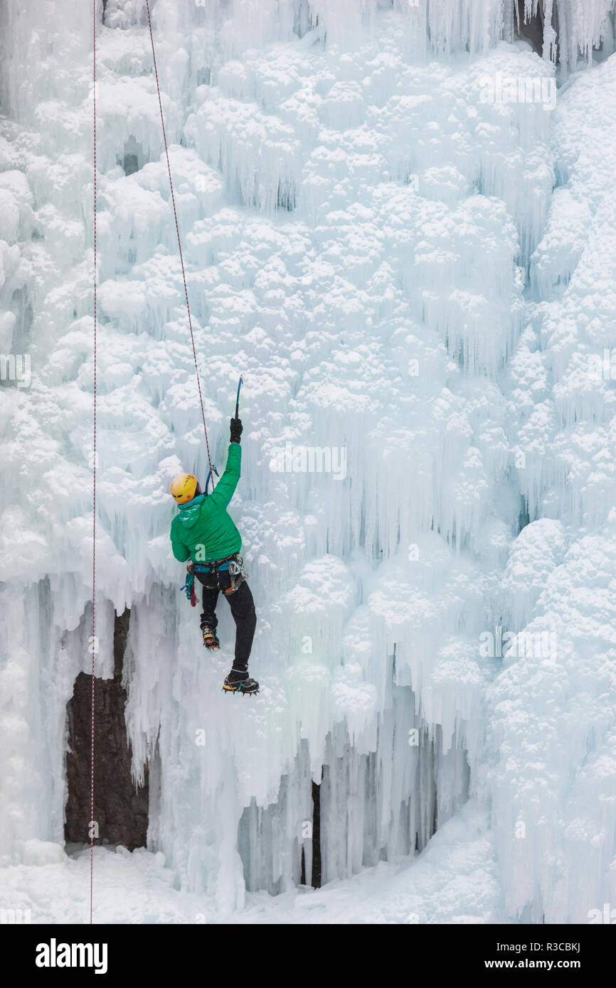 USA, Colorado, Uncompahgre National Forest. Climber ascends icy cliff ...