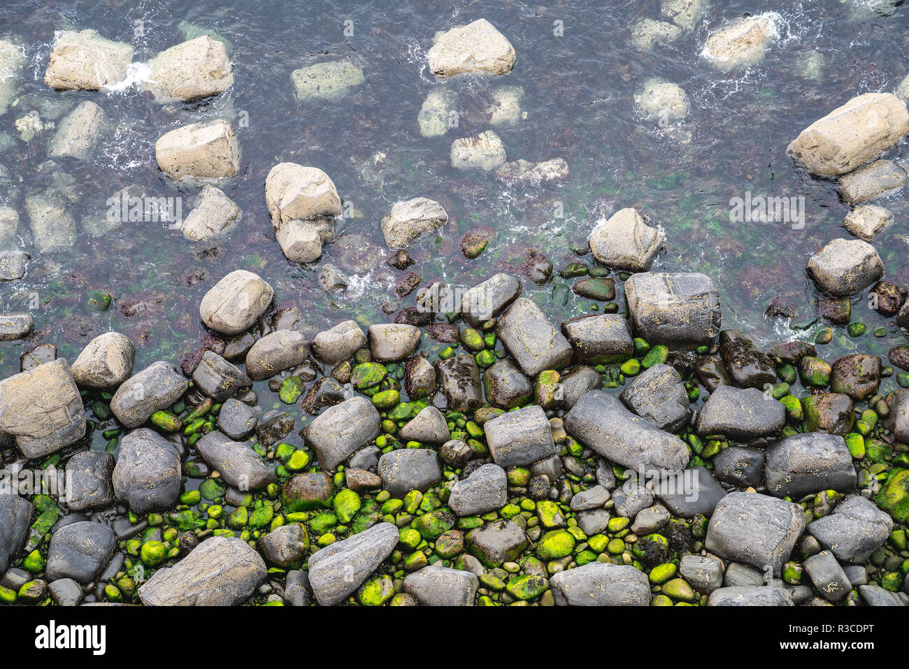 Green stones in water near Kilt Rock, Scotland, UK Stock Photo - Alamy