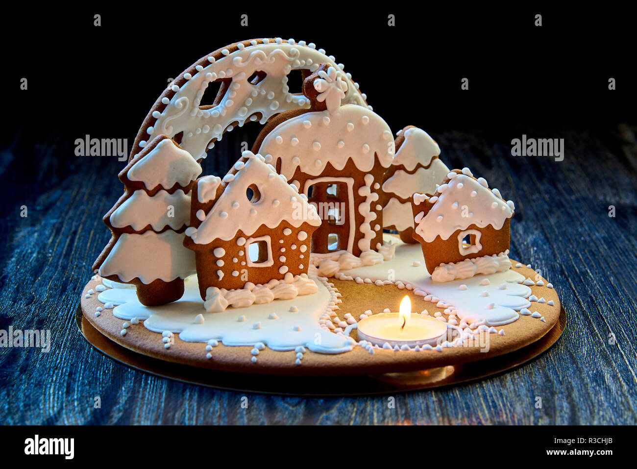Christmas gingerbread house with a burning candle on a dark wooden ...