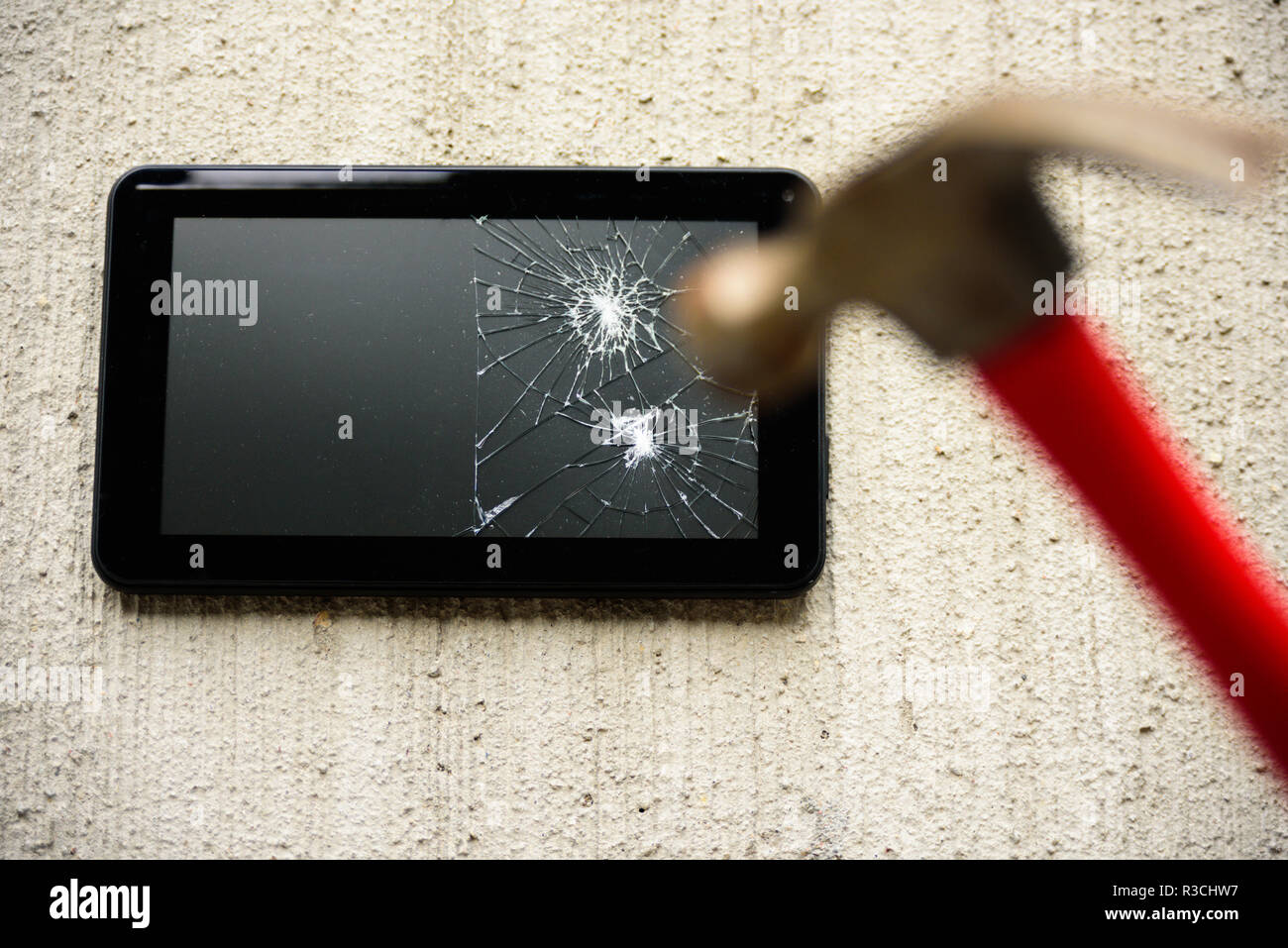 Hammering screen of tablet by old rusty hammer on concrete background ...