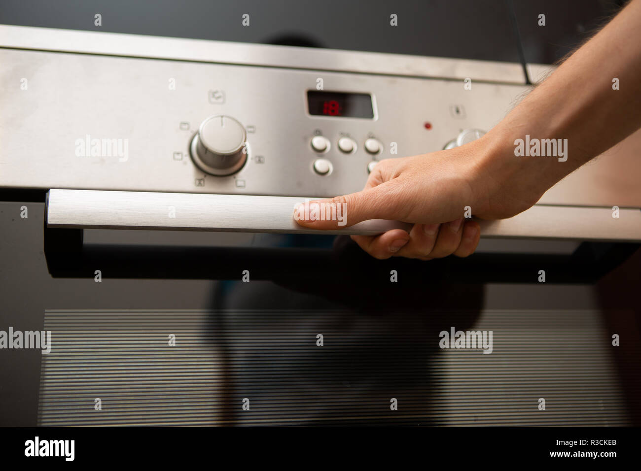 Image of oven and human hand Stock Photo - Alamy