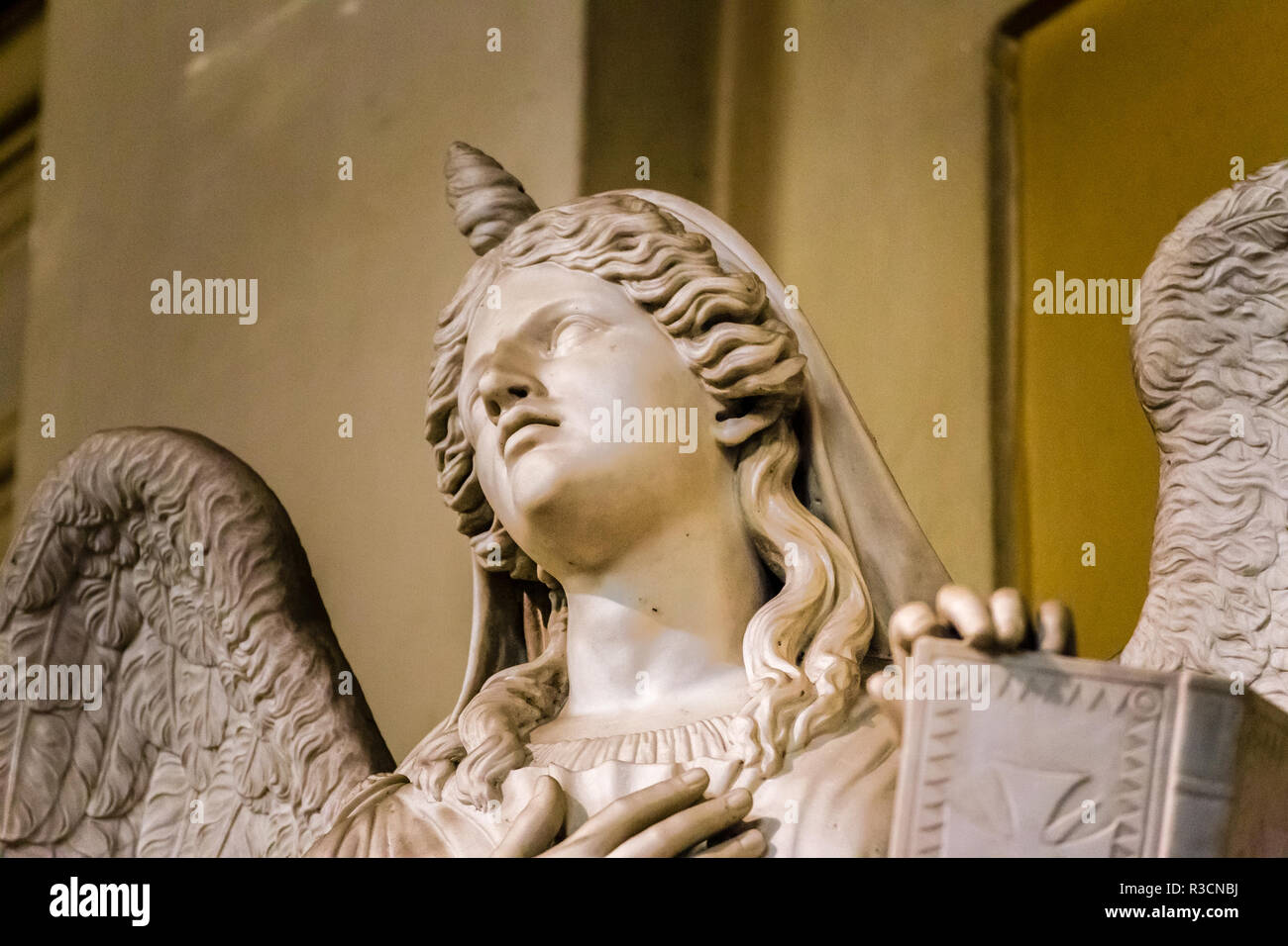 statue of angel holding book Stock Photo - Alamy