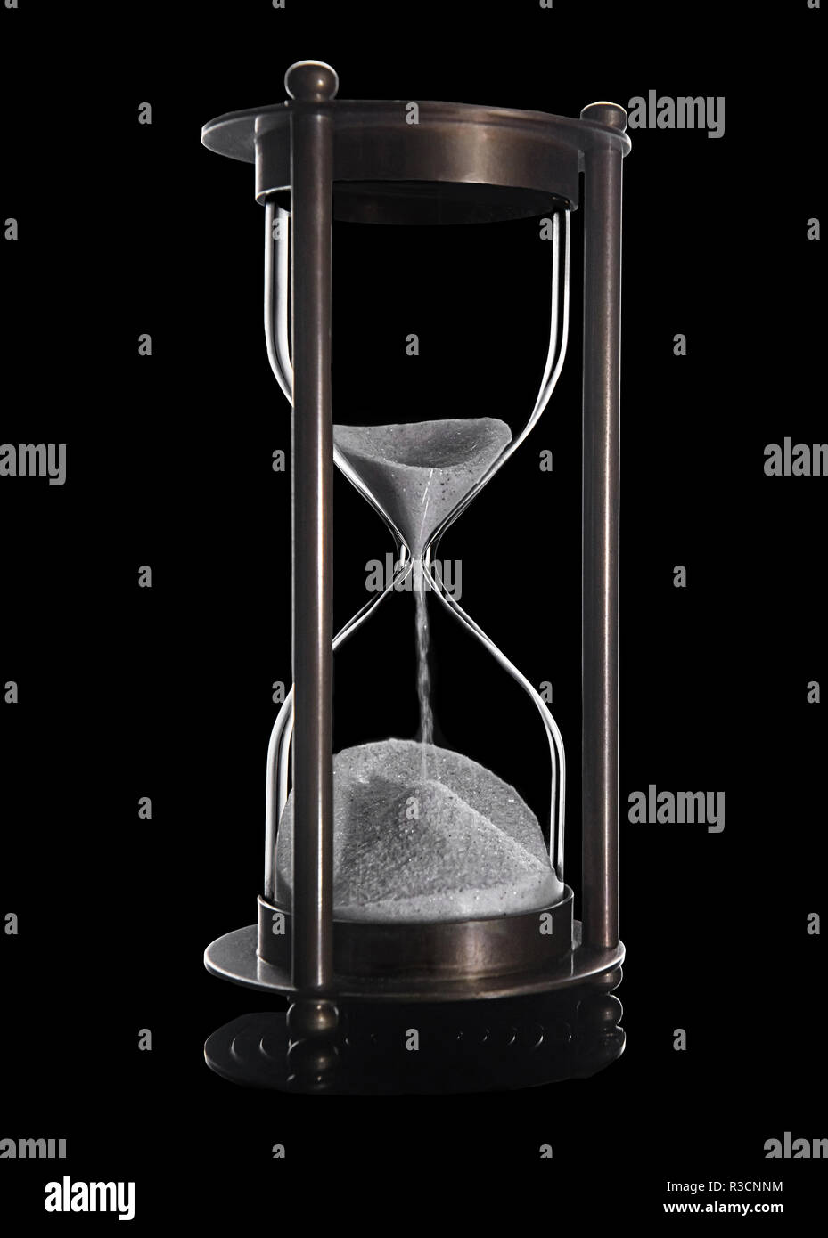 Elegant and stylish bronze vintage sandglass with trickling white sand ...