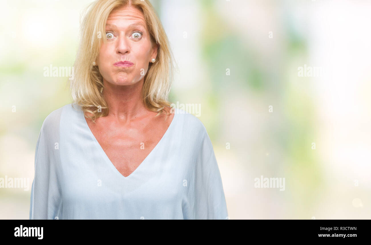 Middle age blonde business woman over isolated background puffing ...