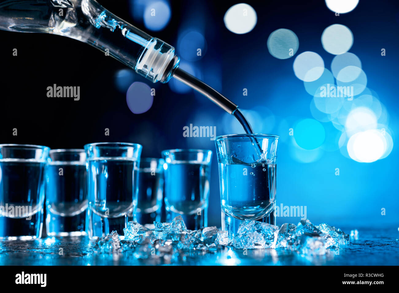 Vodka poured into a glass lit with blue backlight. Copy space.Chilled ...