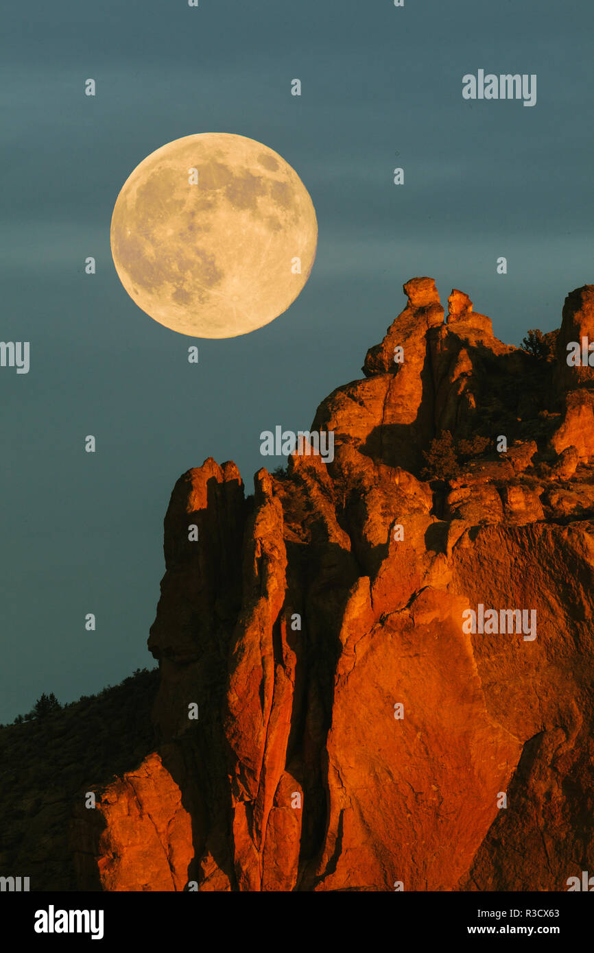 Full moon at sunrise above the basalt cliffs of Smith Rock State Park ...