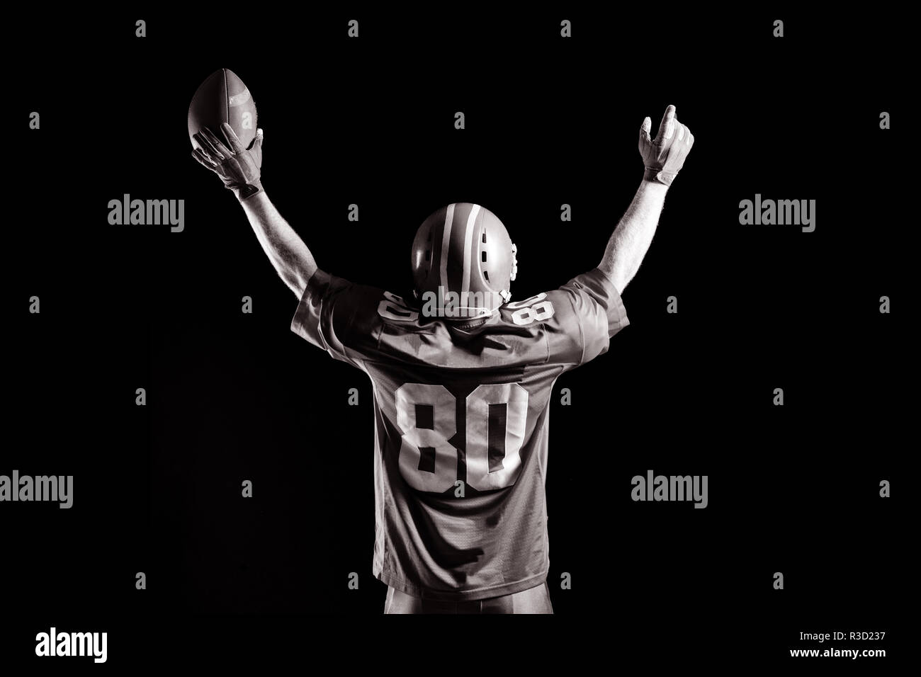 American football player cheering with arms up Stock Photo - Alamy